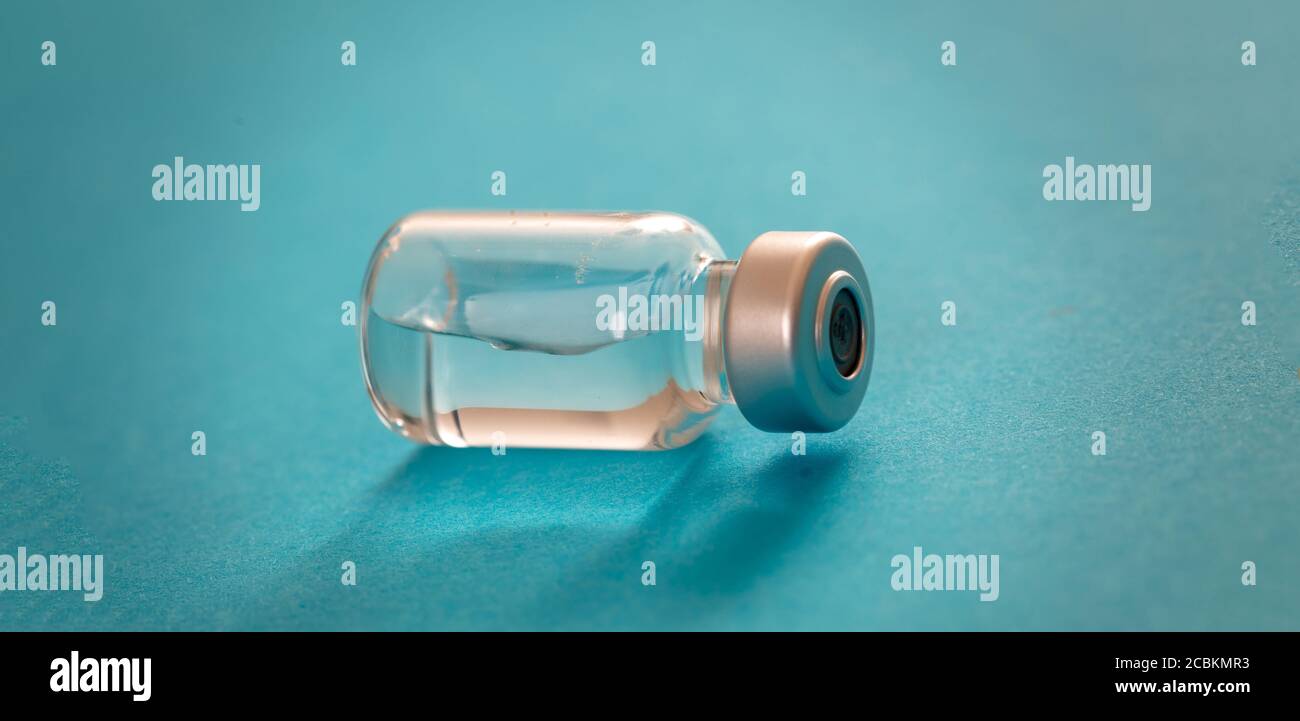 Medical vial for injection on blue background, transparent glass bottle ...