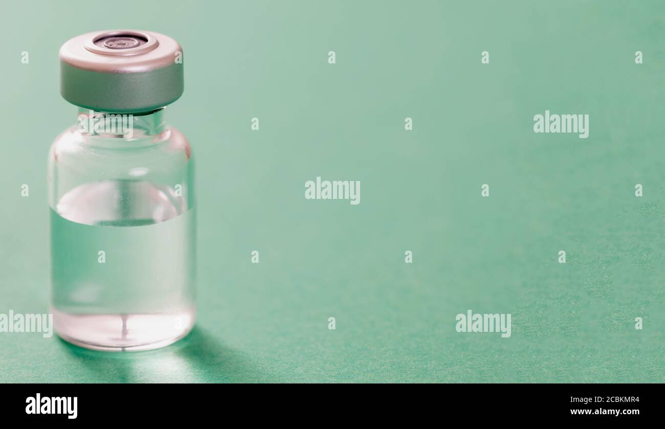 Medical vial for injection on green background, transparent glass ...
