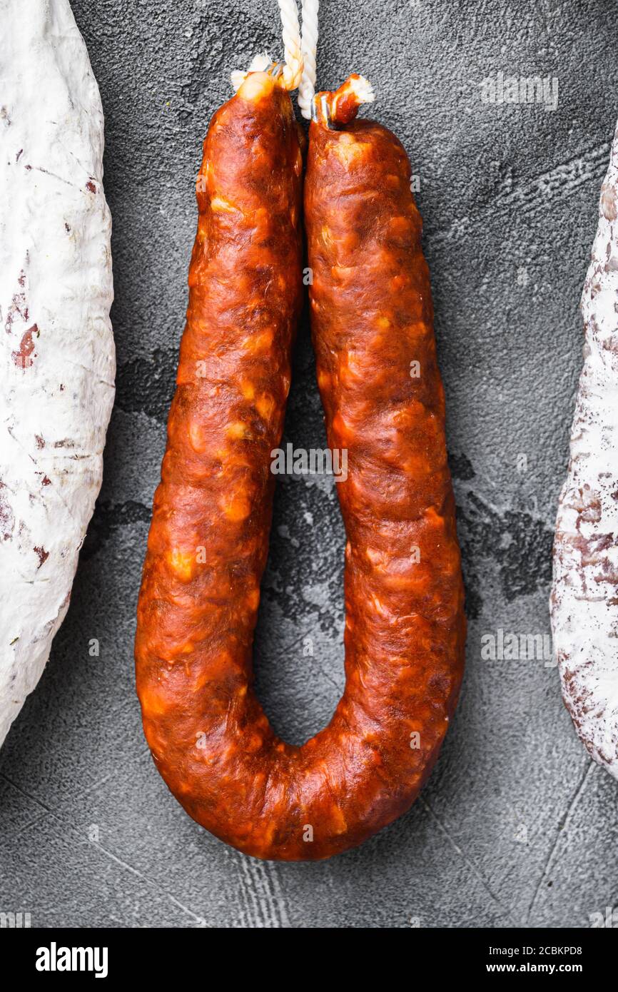 Spanish dry salami from a rack at market on grey textured background ...