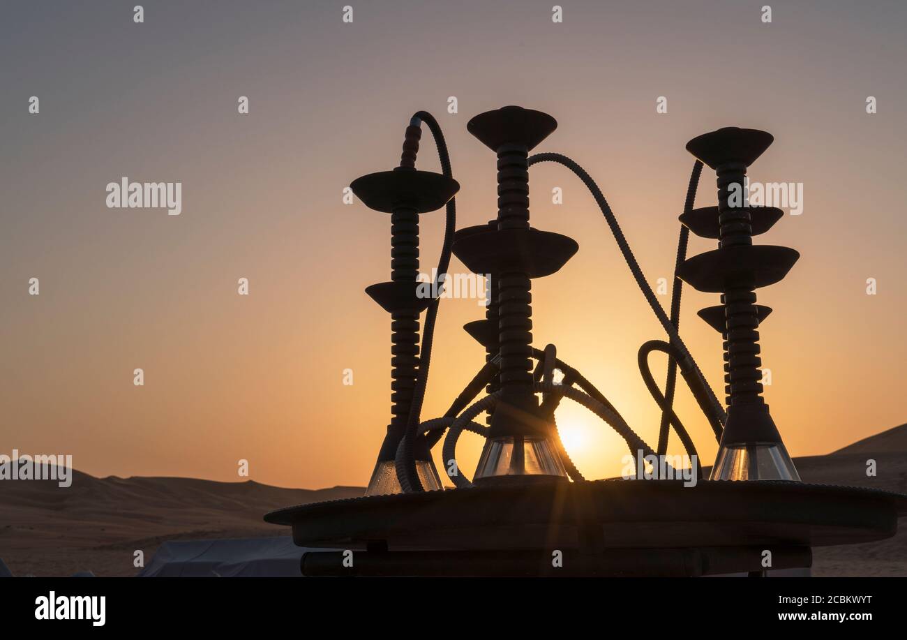 Arab shishas (Water pipes) on a table in the desert at sunset, Abu ...