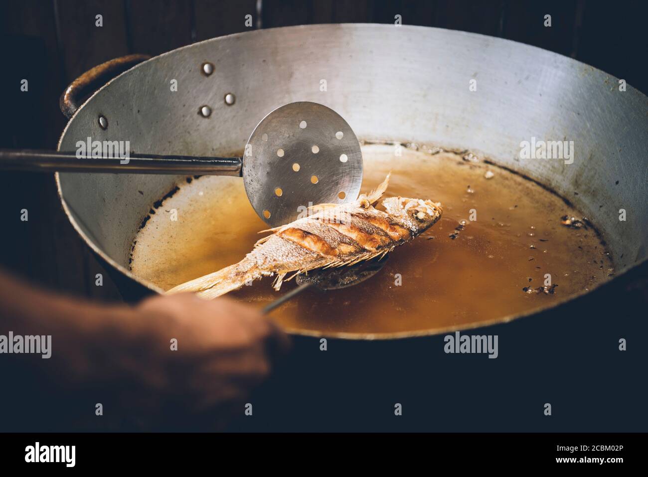 Person cooking fish in pan, close-up, Tulum, Mexico Stock Photo - Alamy