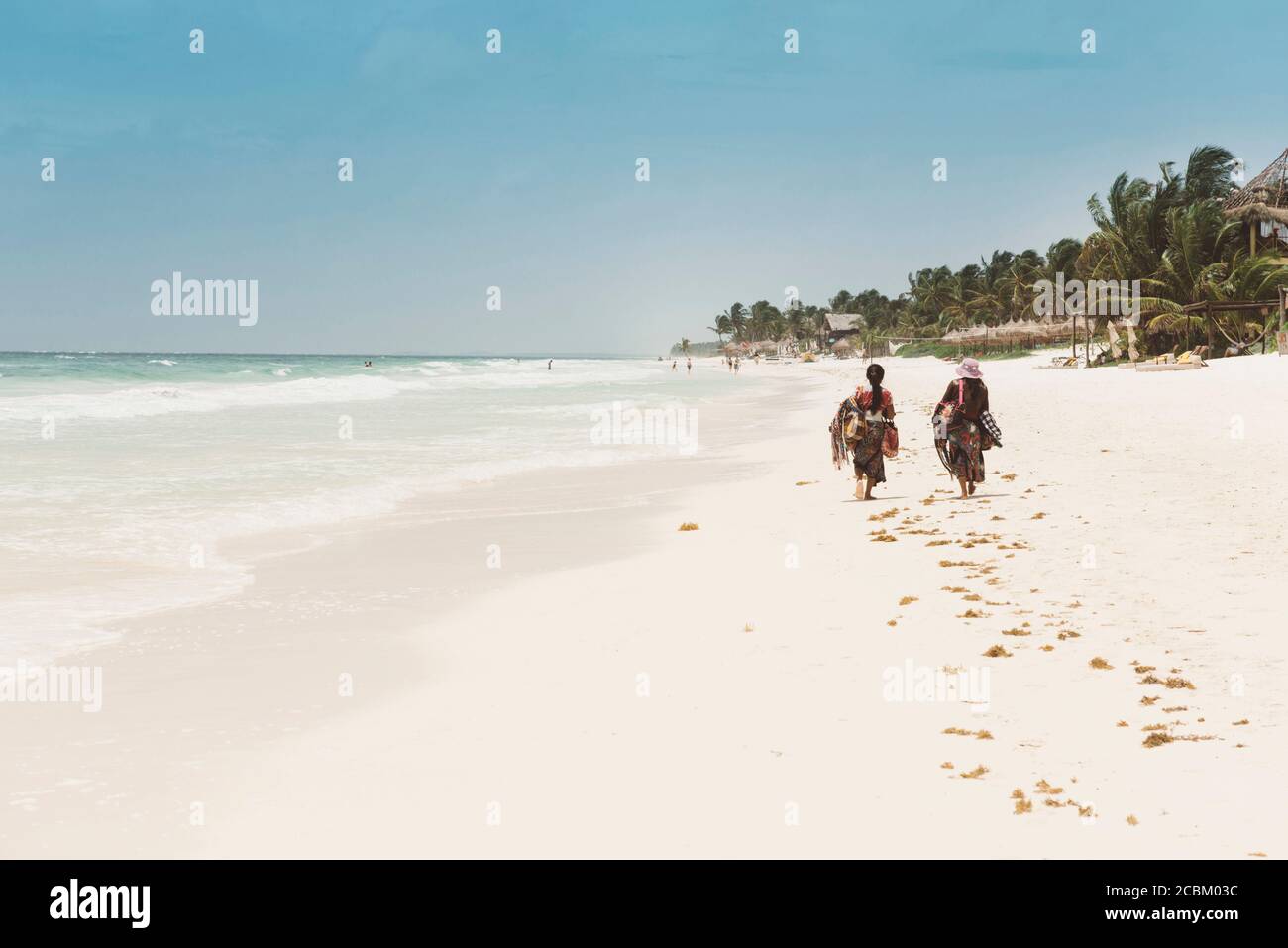 Two local people walking along beach, Tulum, Mexico Stock Photo - Alamy