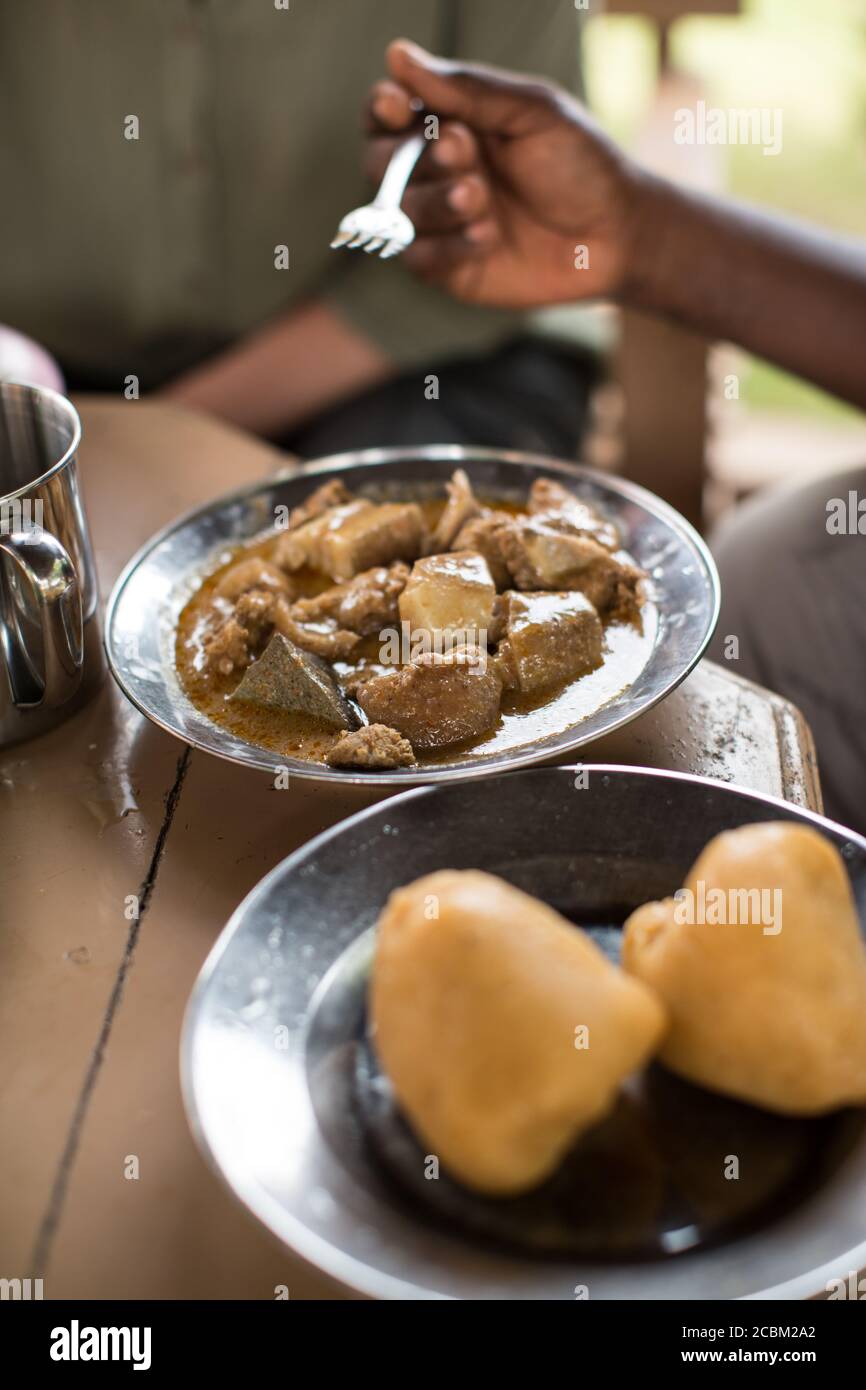 Person eating traditional African meat dish, mid section, Cotonou ...