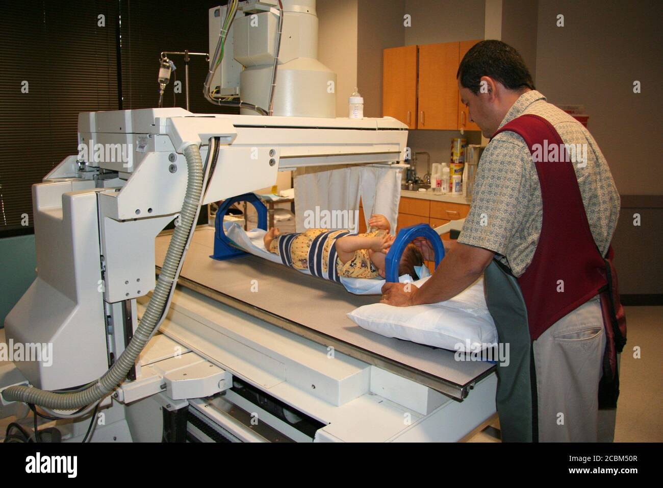 Austin, Texas USA, 2006: Father wearing lead apron watches his 10-month ...
