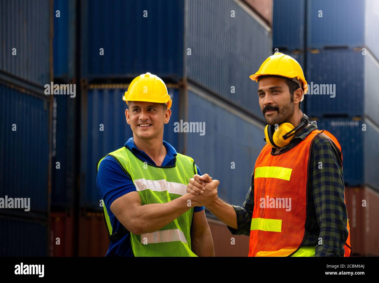 Two Industrial workers or engineers join hands together for better work ...