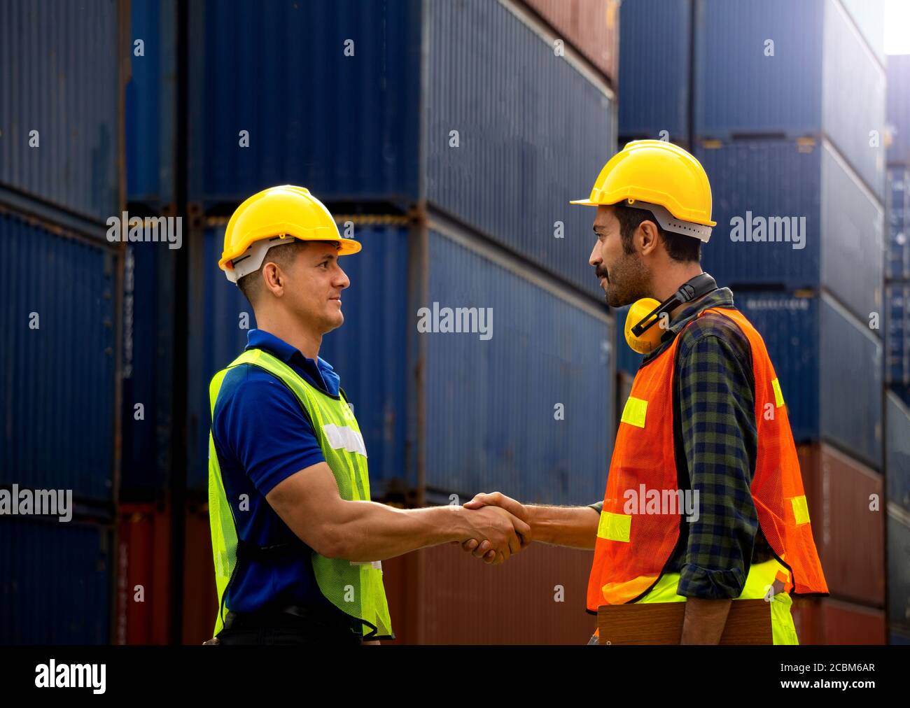 Two Industrial workers or engineers join hands together for better work ...