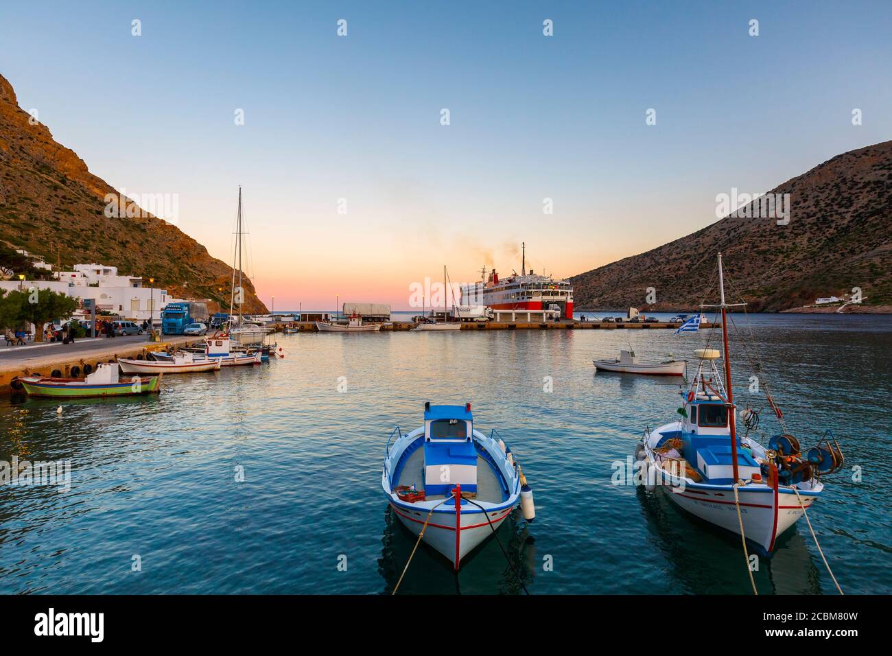 Fishing boats and a ferry in port of Kamares on Sifnos island, Greece ...