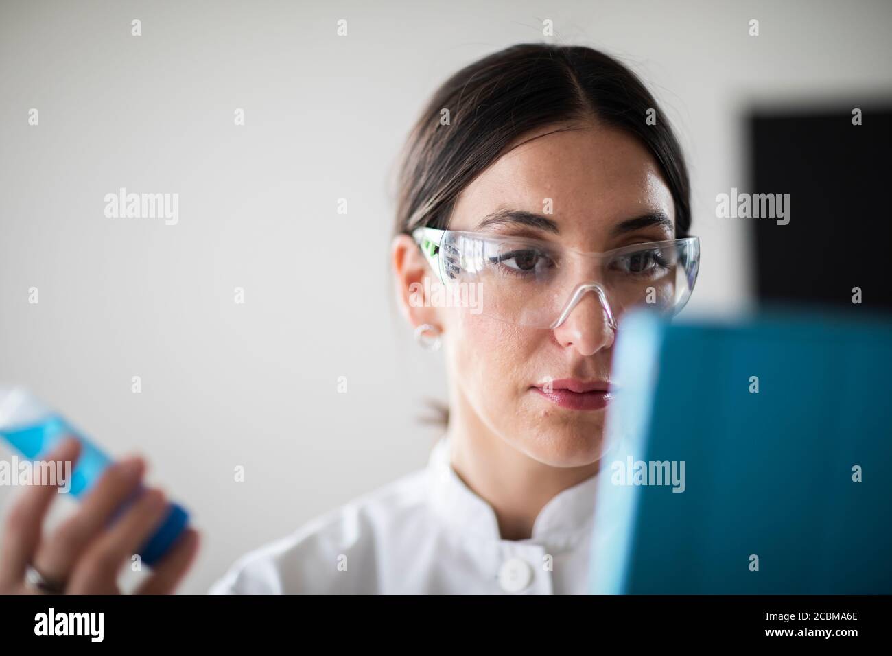 scientist female with lab glasses, tablet and tubes in a lab Stock ...
