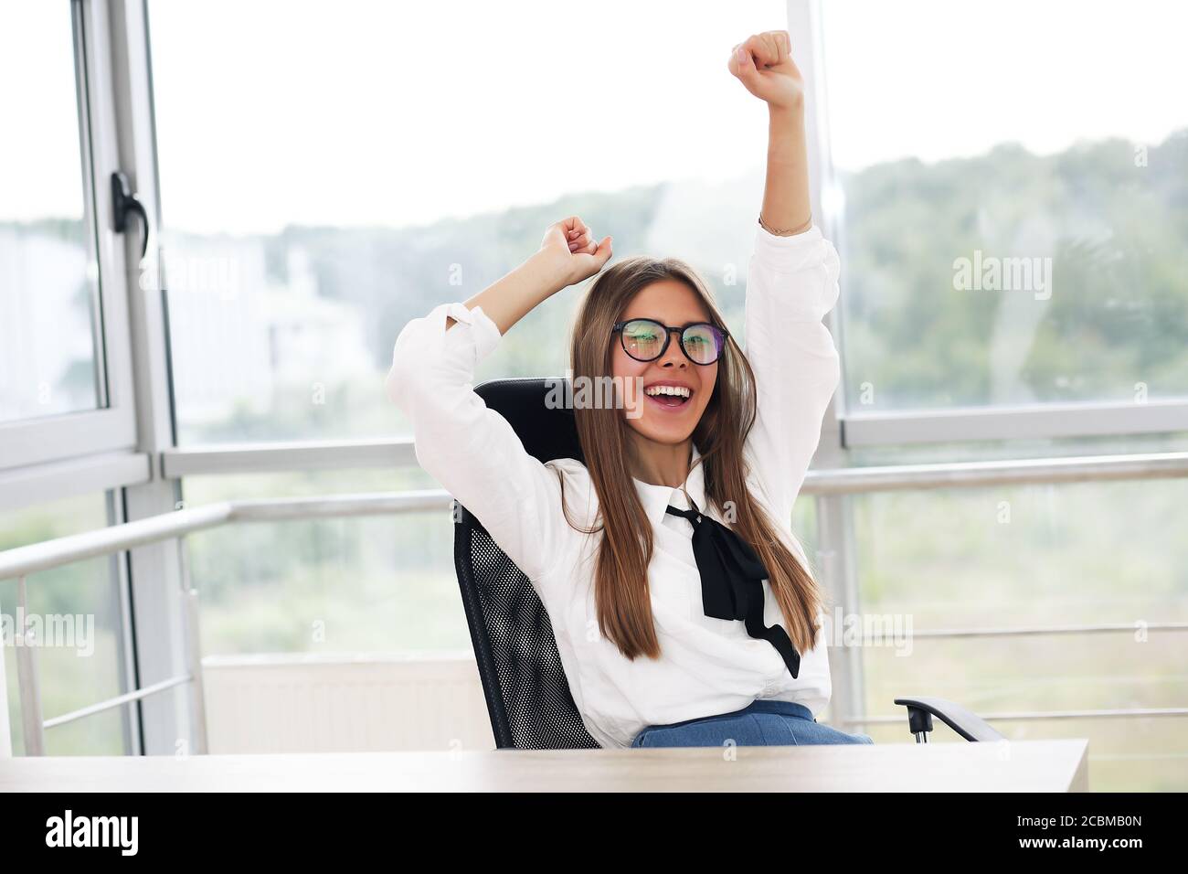 girl in a businessman shirt, she is happy hands up Stock Photo - Alamy
