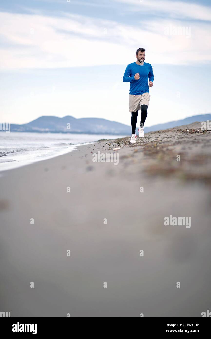 Man jogging on the beach in the morning Stock Photo - Alamy