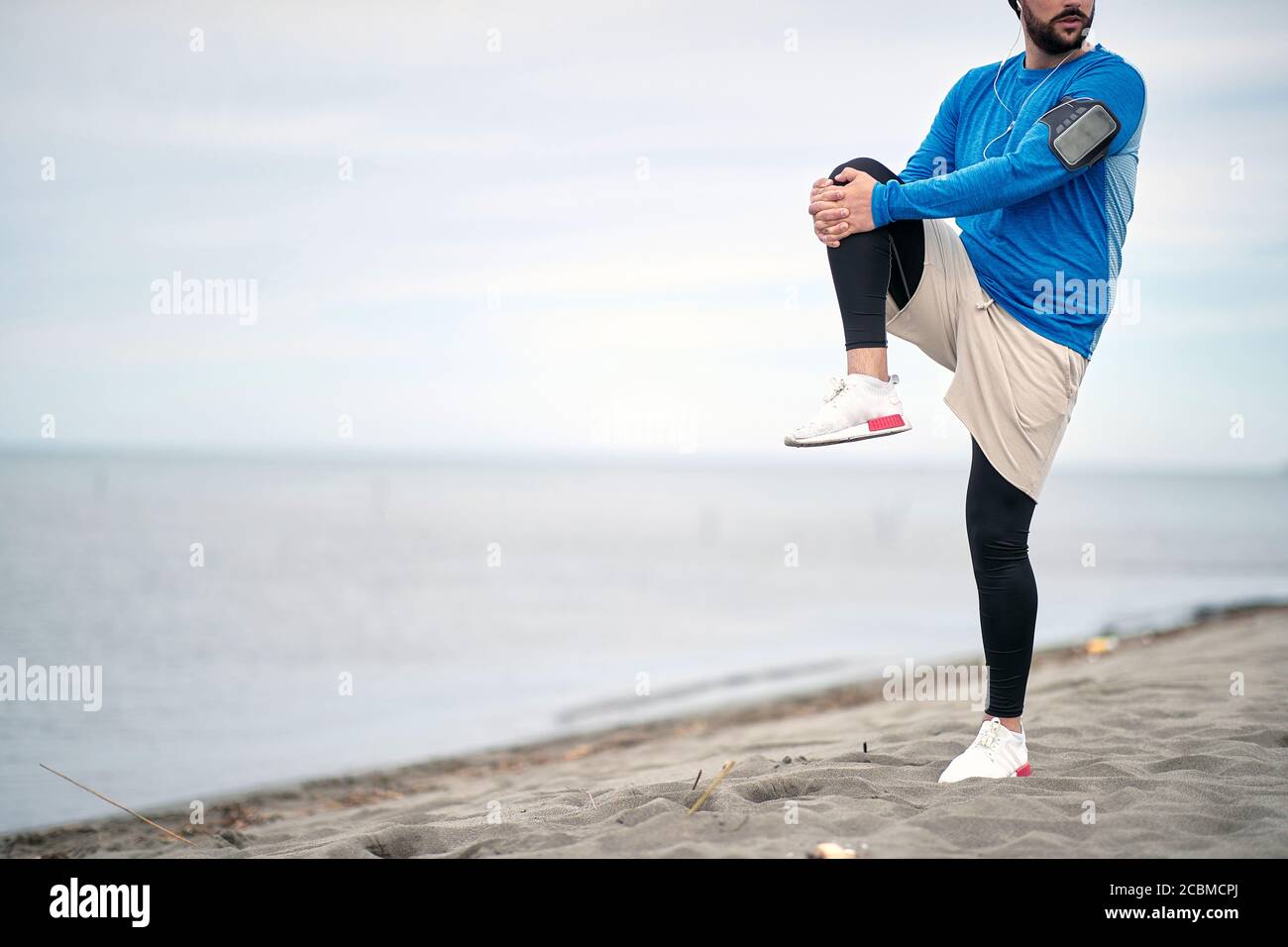Man stretching alone on the beach; Active lifestyle concept Stock Photo ...