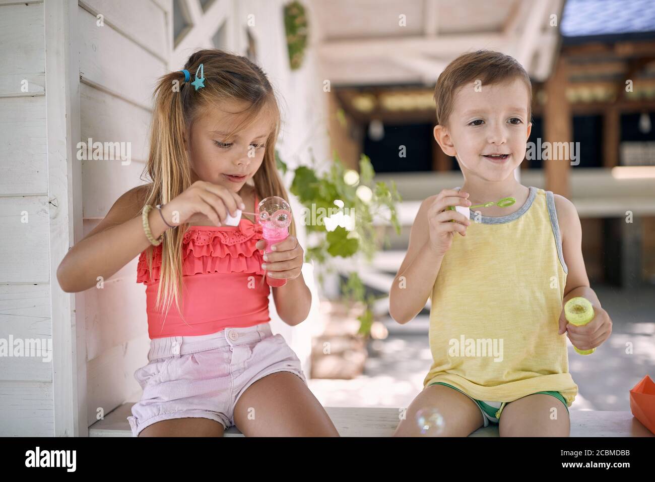 Happy children enjoying in soap bubbles.Boy and girl blow soap bubbles ...