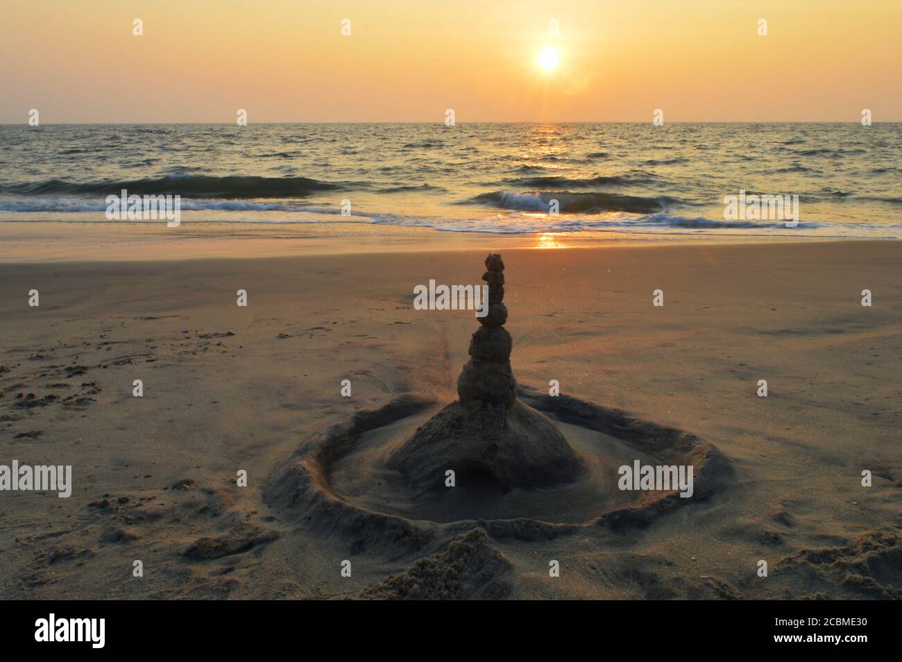 Image shows setting sun at the beach. A sunset represents ending ...