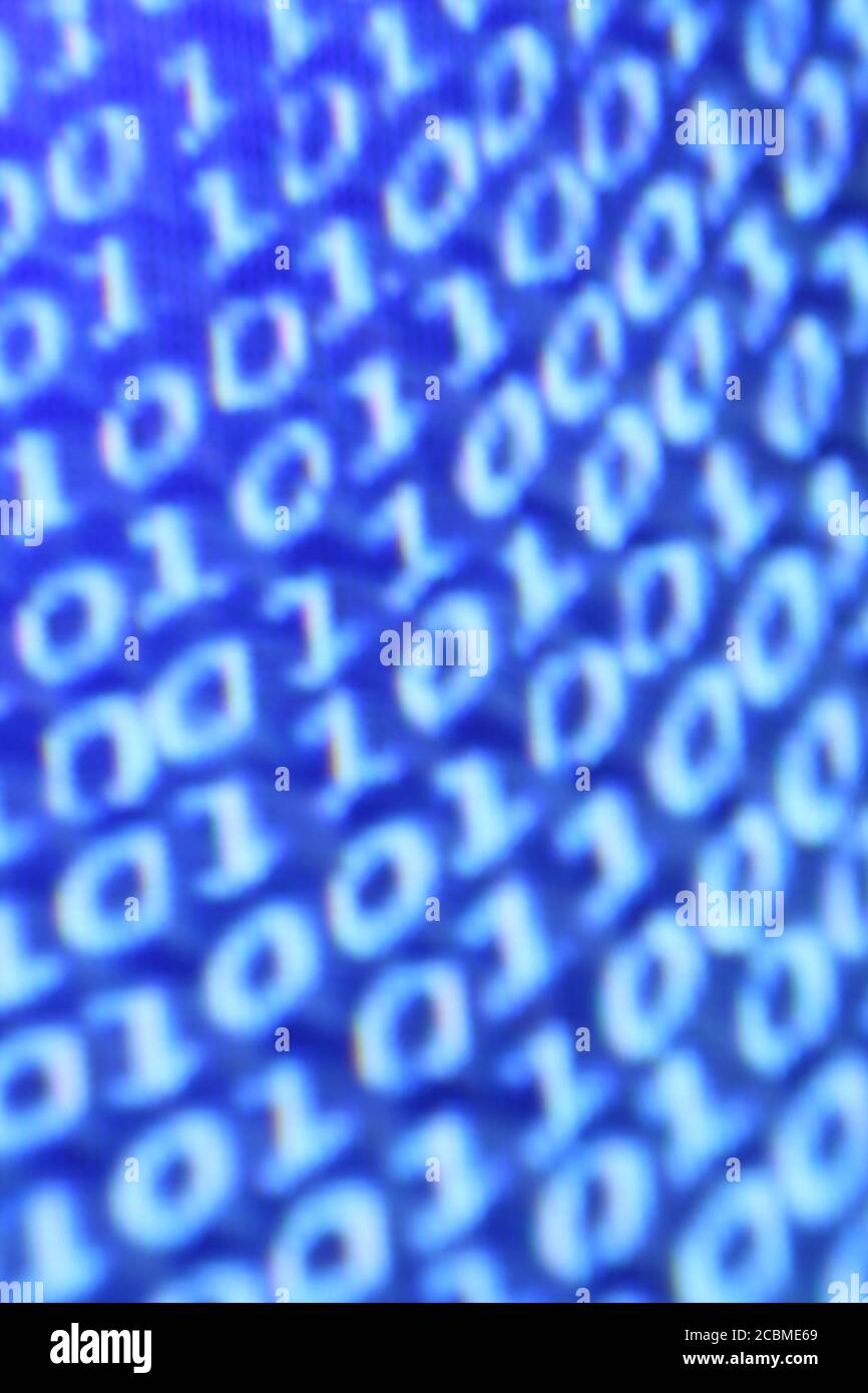 Vertical closeup shot of a blue blurred screen displaying binary codes ...