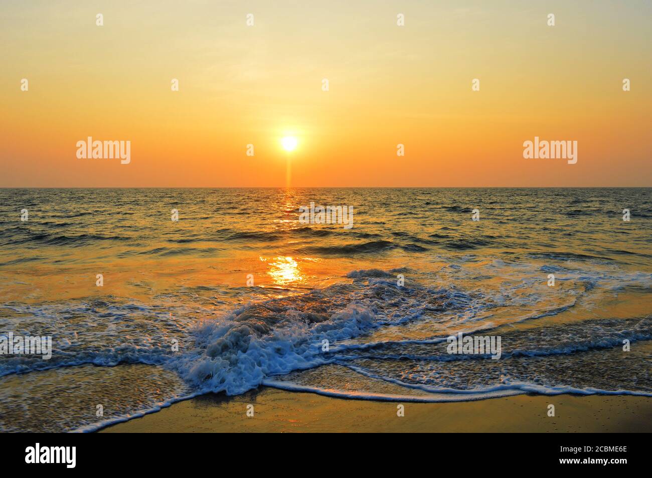 Image shows setting sun at the beach. A sunset represents ending ...