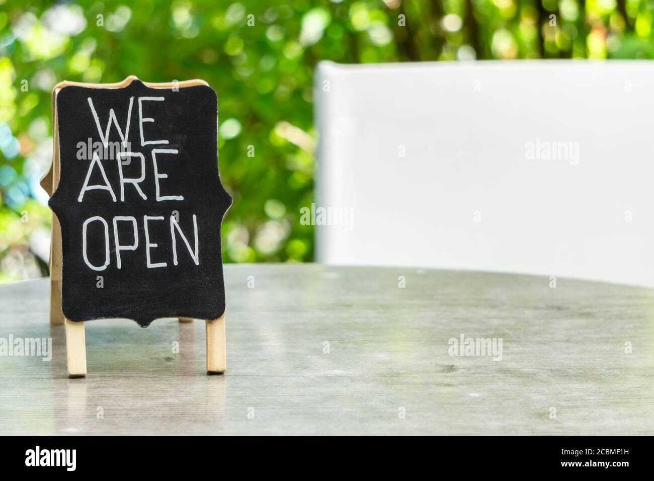 Handwritten word Open on blackboard closeup on cafe table outdoors ...