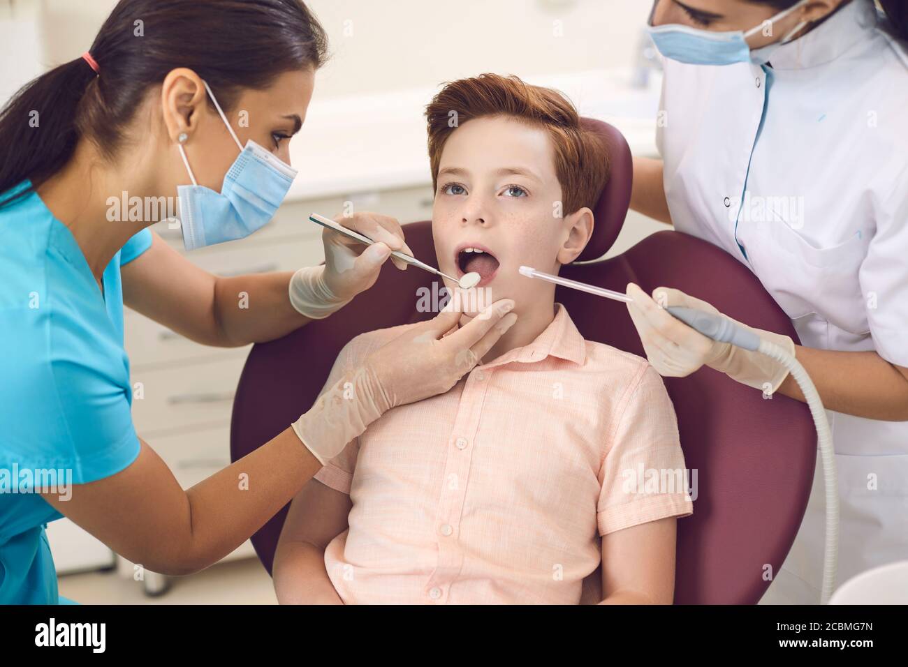 Children dental dentist treats a boy tooth in the office clinic Stock ...