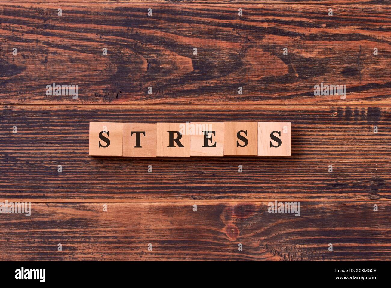 Stress word written on wood block on dark rustic wooden background ...
