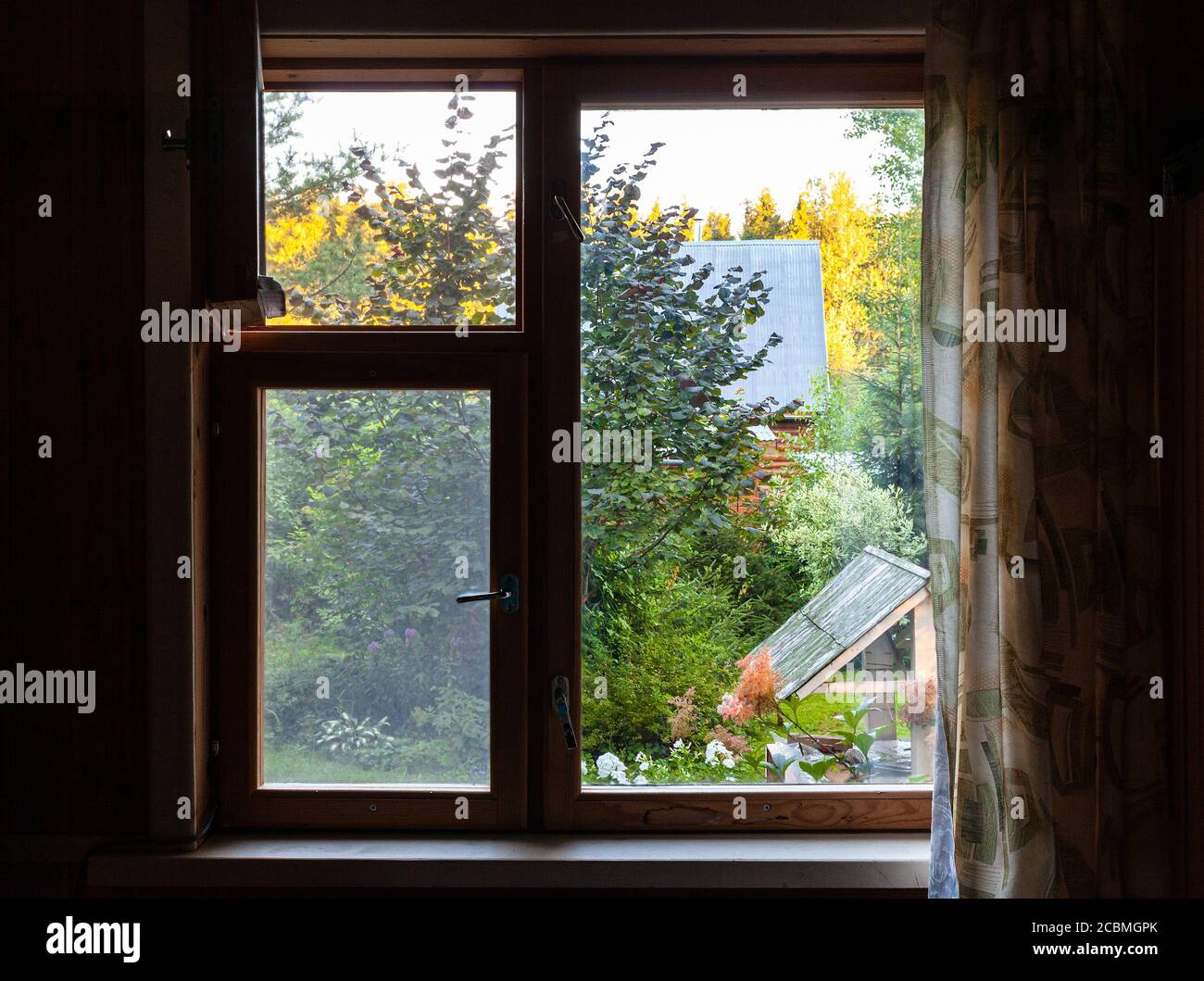 view of green backyard with well through window in rural house at ...