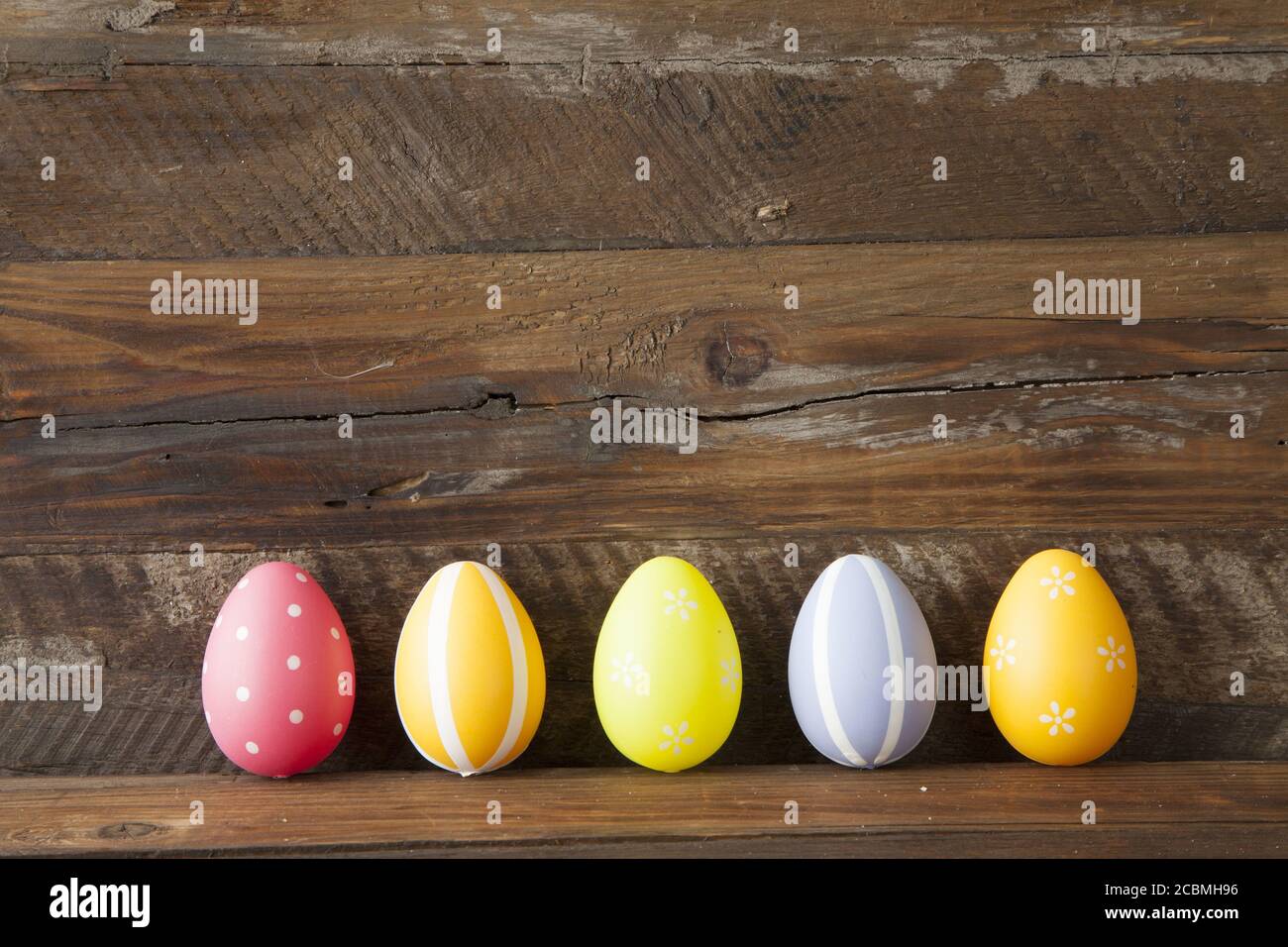 Row of colorfully decorated eggs with different patterns on a wooden ...