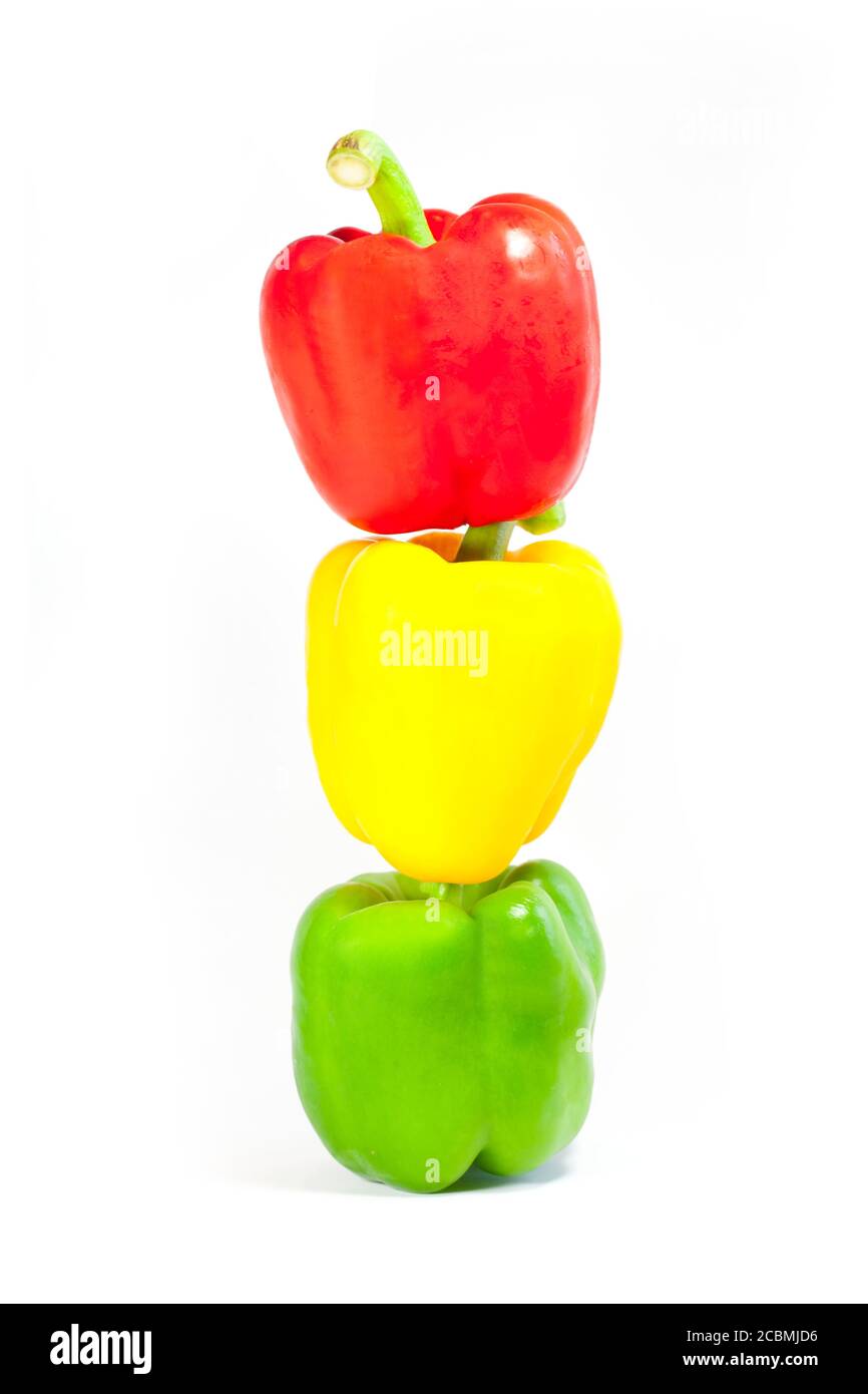 Vertical shot of red, yellow and green bell peppers on each other ...