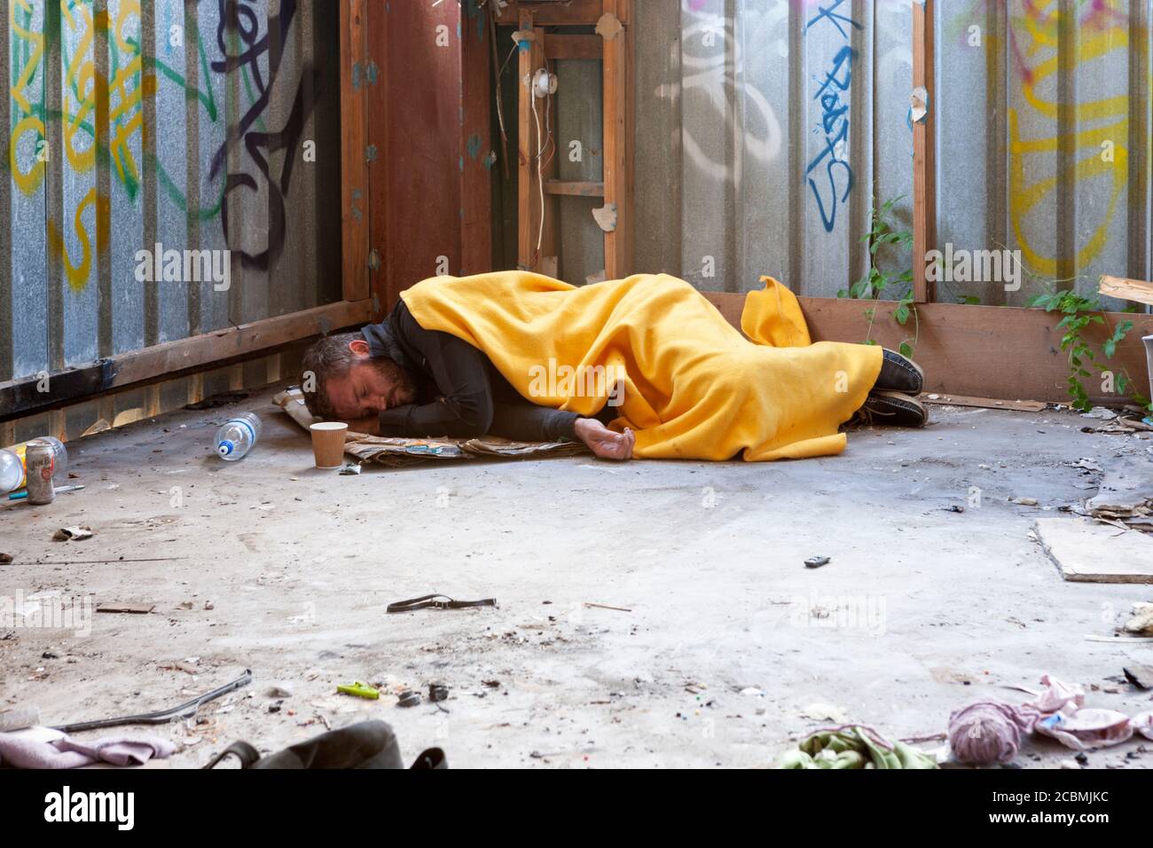 A homeless man lying on the ground Stock Photo - Alamy