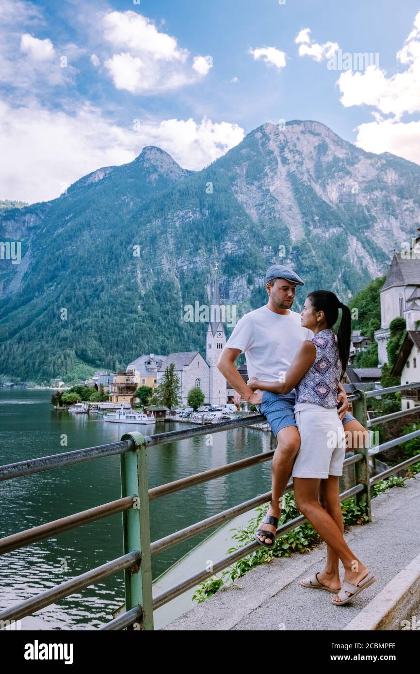 couple visit Hallstatt village on Hallstatter lake in Austrian Alps ...