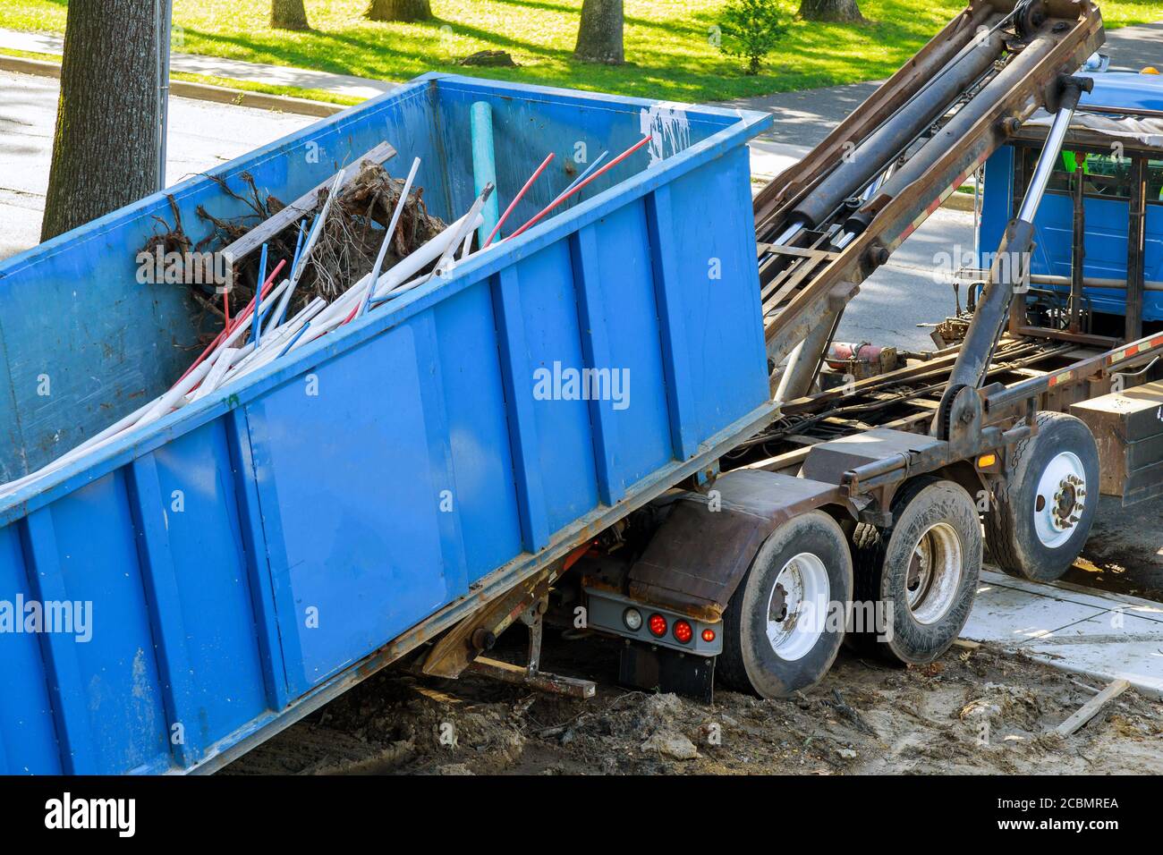 Metal trash container loading the garbage can waste construction trash ...