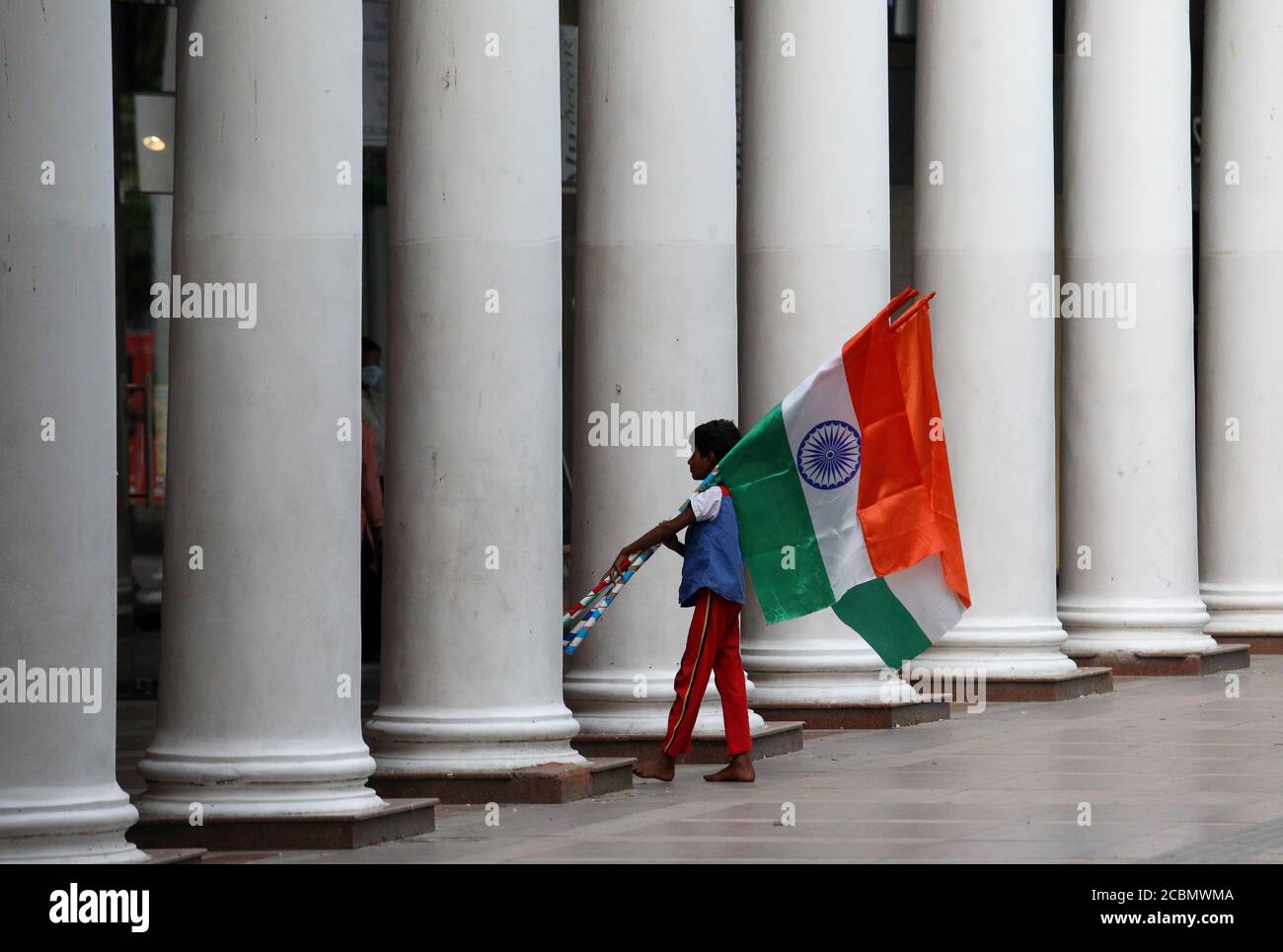 A boy sells Tricolour flags on the eve of Independence Day at Connaught ...