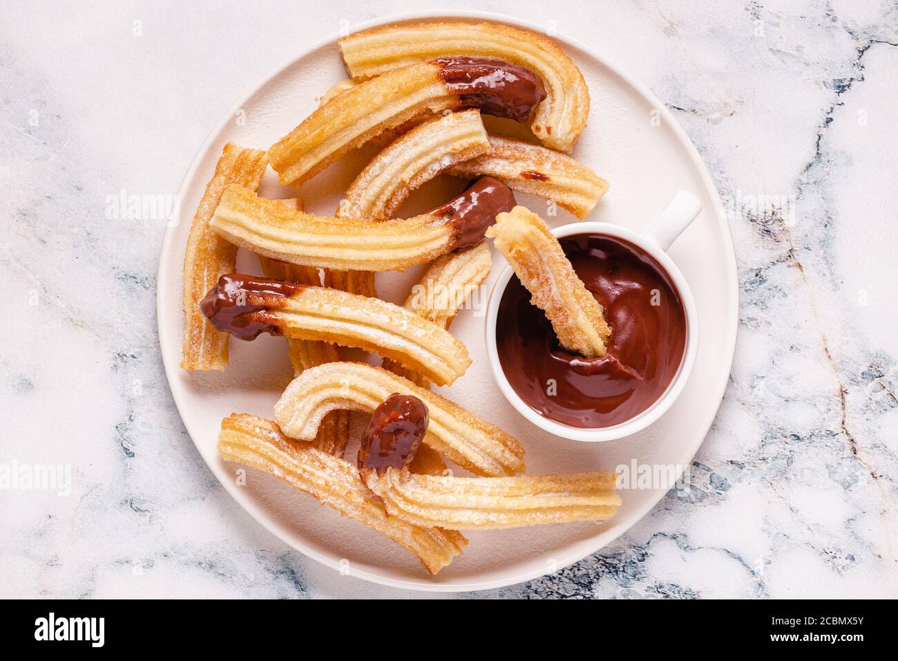 Churros with powdered sugar and chocolate sauce, top view Stock Photo ...