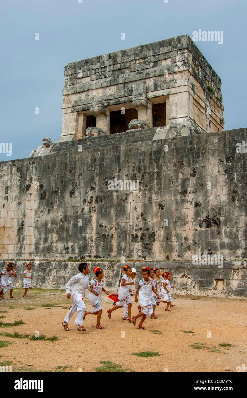A group of Mayan children (dance group) running through the great ball ...