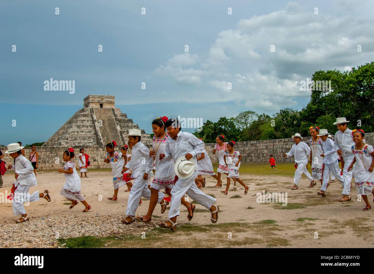 A group of Mayan children (dance group) running through the great ball ...
