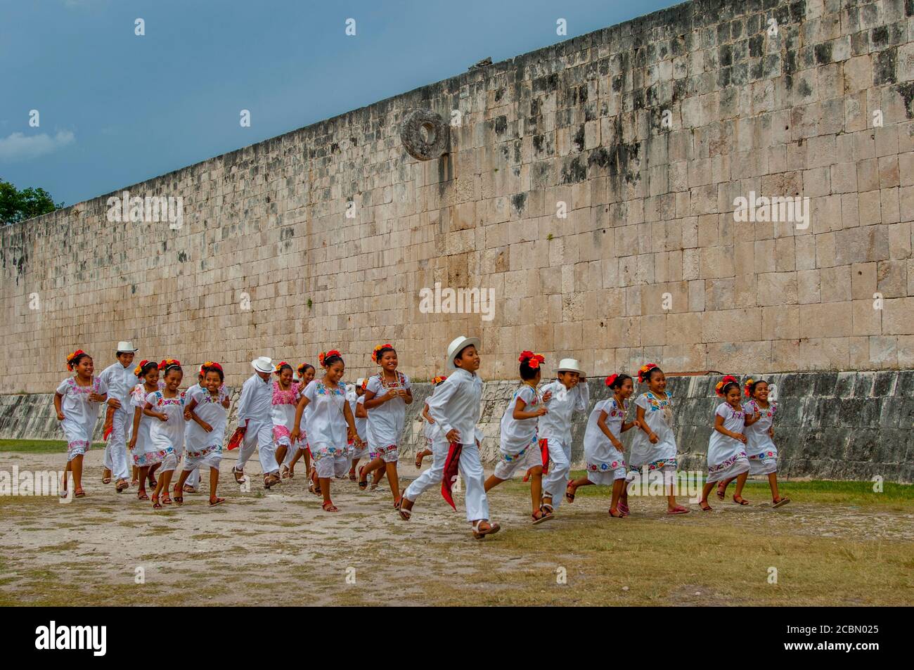 A group of Mayan children (dance group) running through the great ball ...