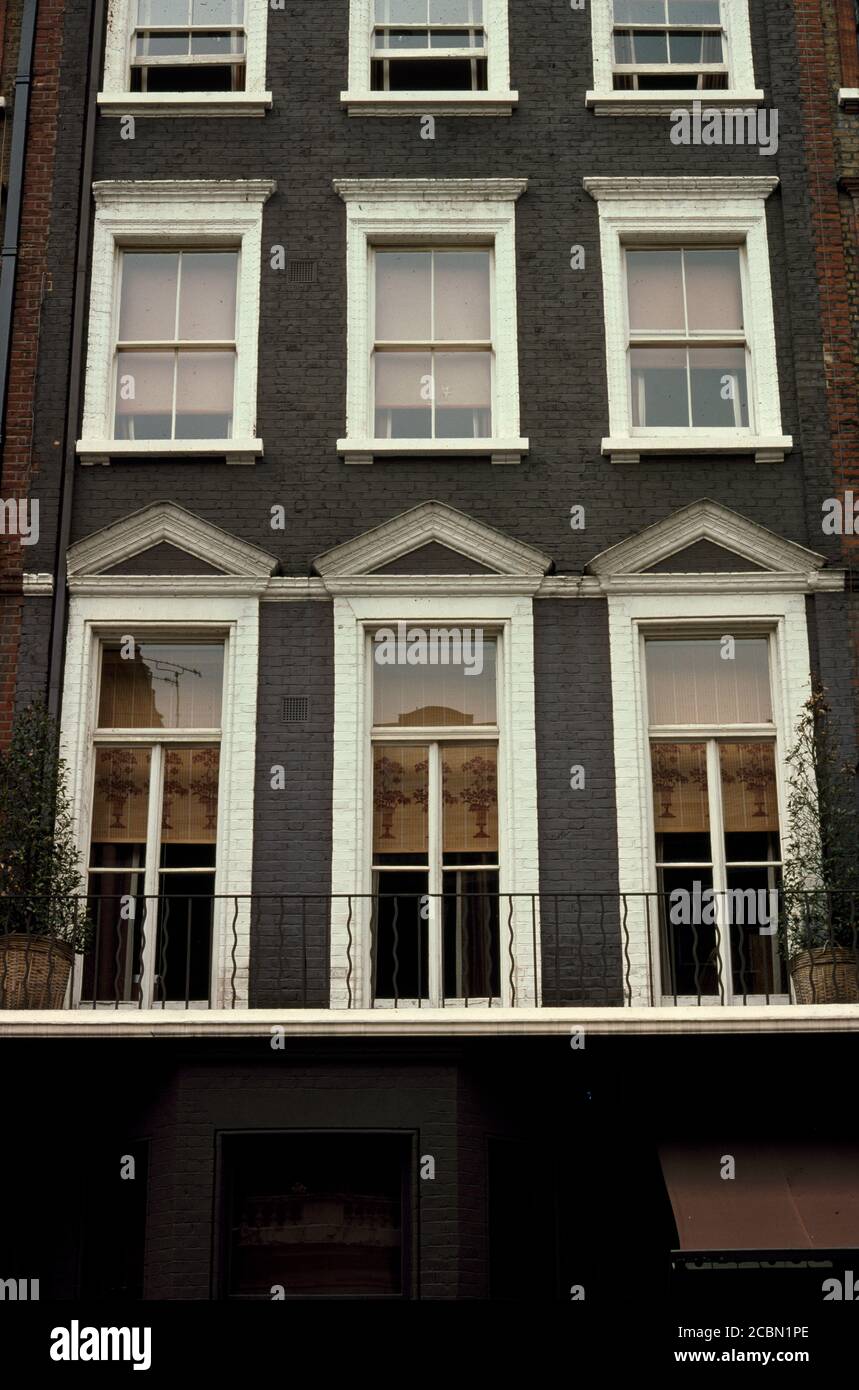 Detail of front of building with three rows of windows at each level ...