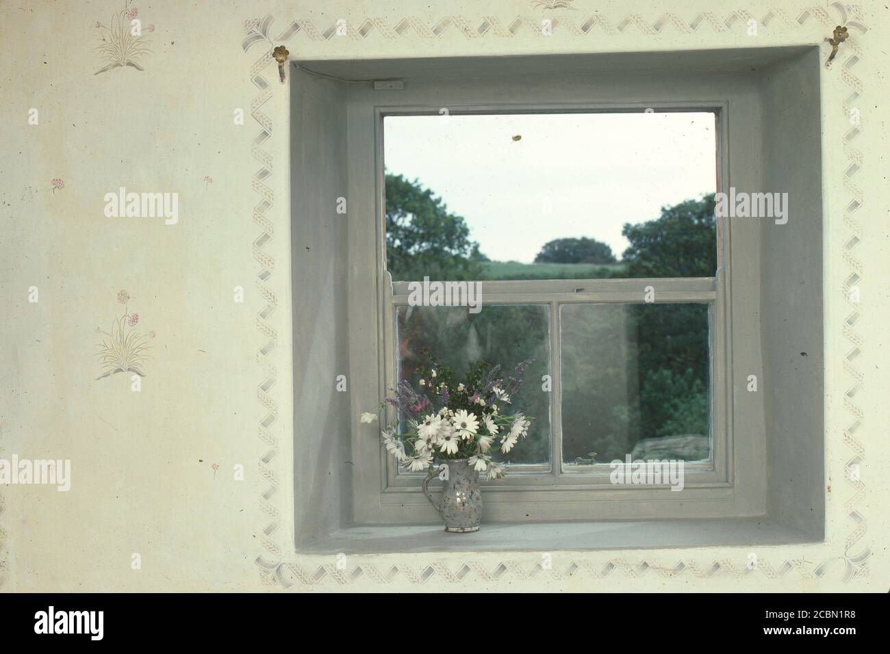Small grey window with stencil round outside Stock Photo - Alamy