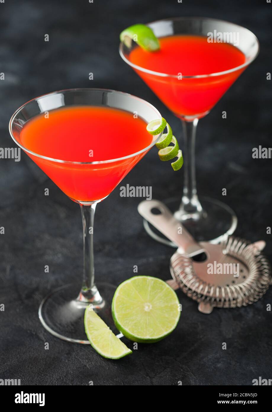 Cosmopolitan cocktail in classic crystal glasses with lime peel and ...