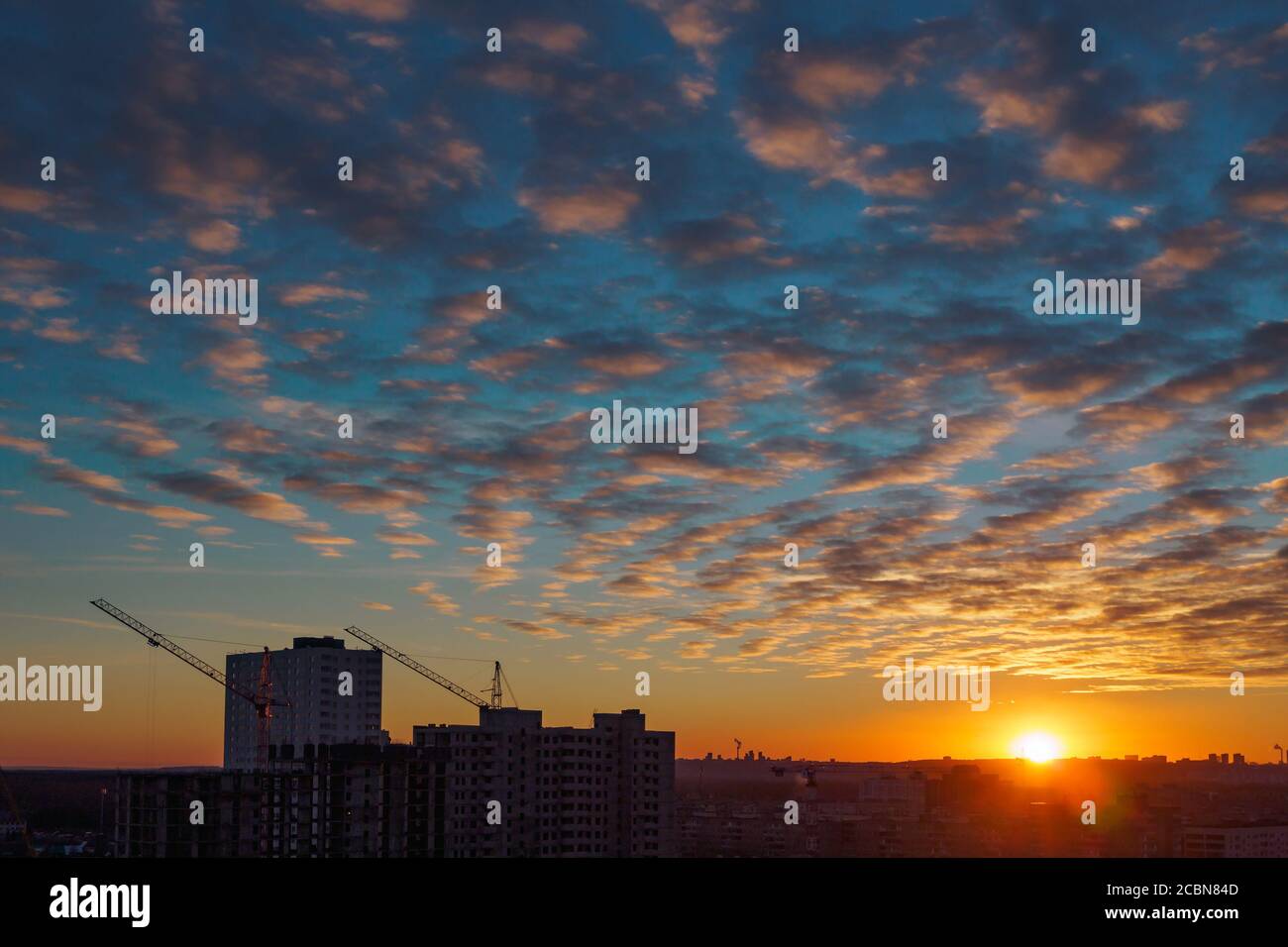 Cityscape with sunset and cirrus clouds. View of building under ...