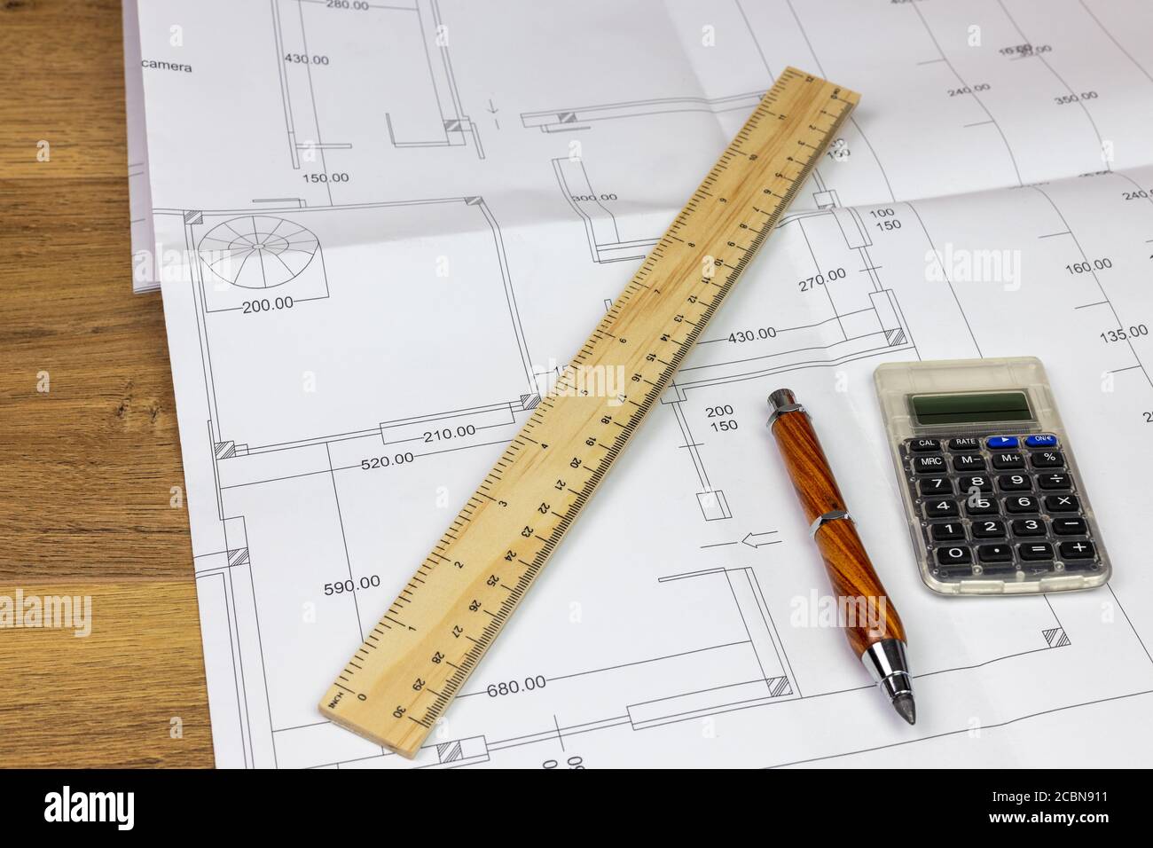 desk with building construction plan resting on top with ruler, pencil ...