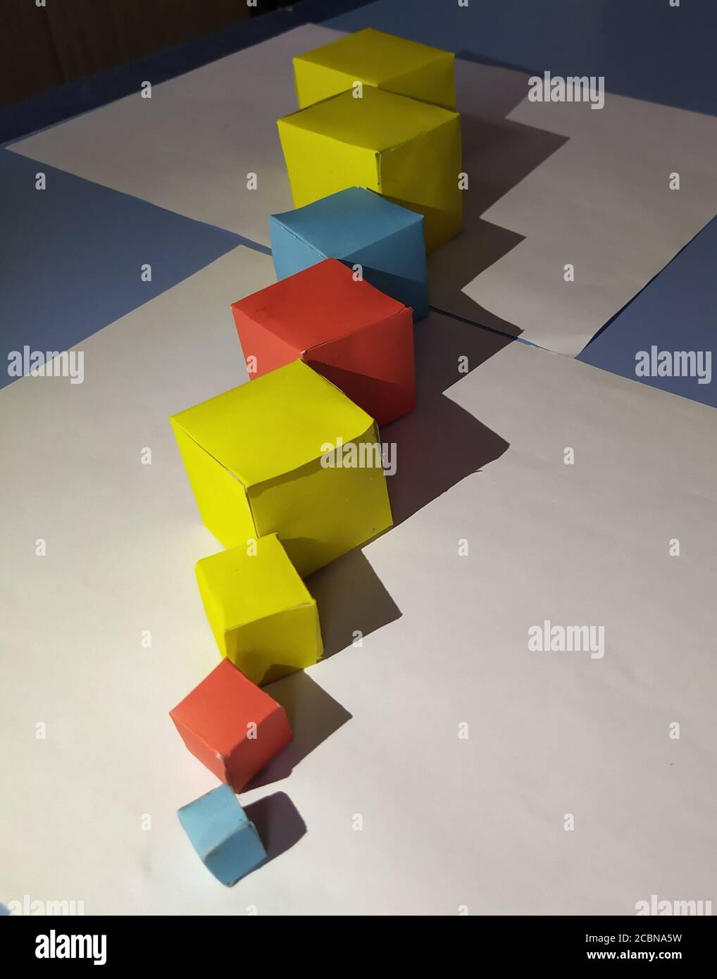Vertical shot of colored cardboard cubes lined back Stock Photo - Alamy