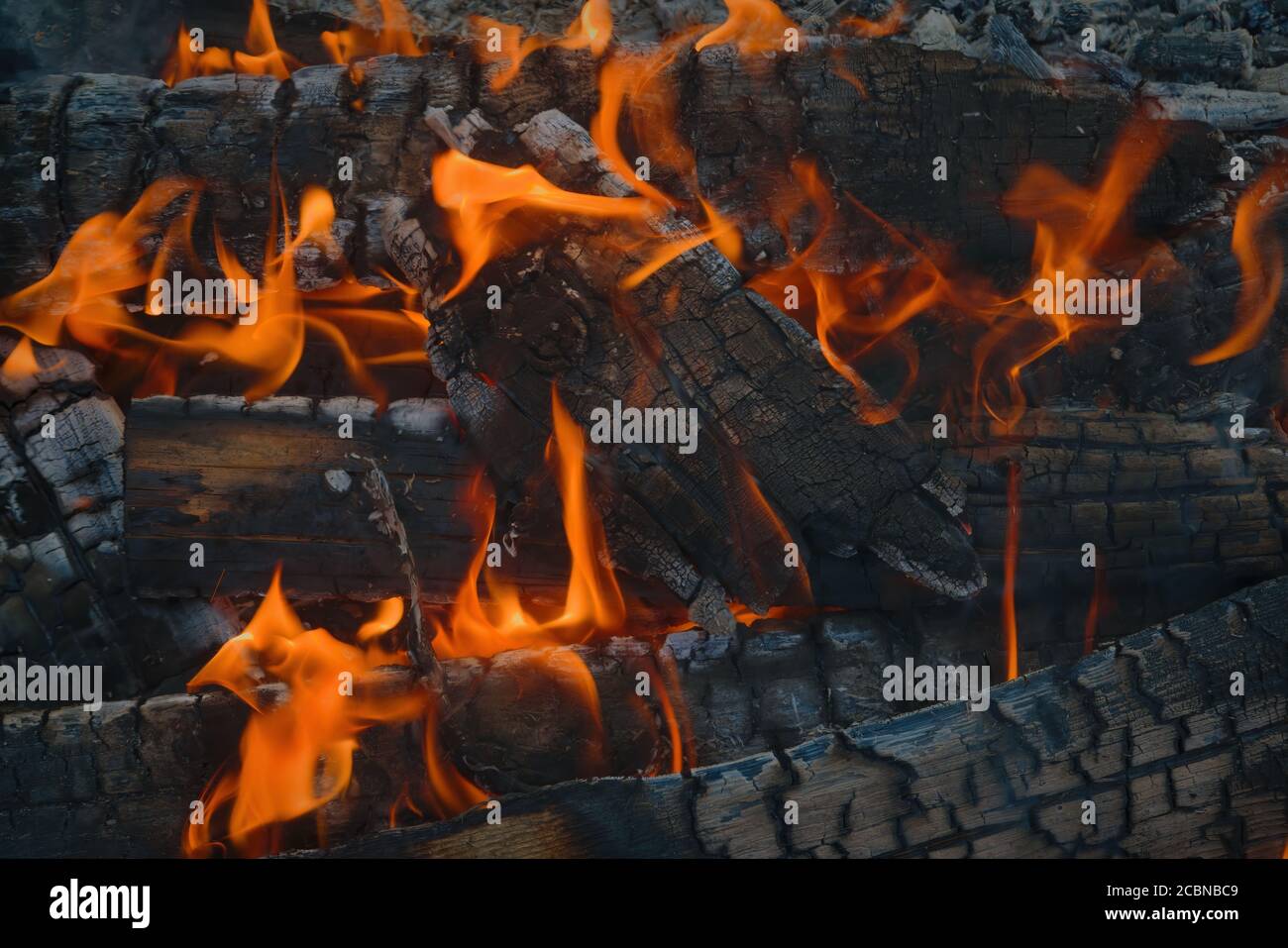 Burning log of wood close-up as abstract background. The hot embers of ...
