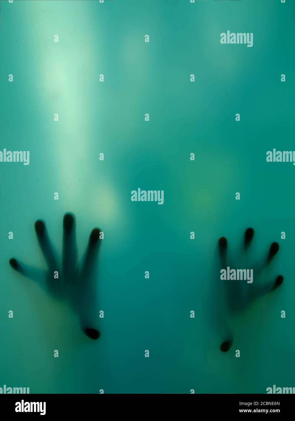 Vertical shot of scary hands of a woman from the back of a green glass ...