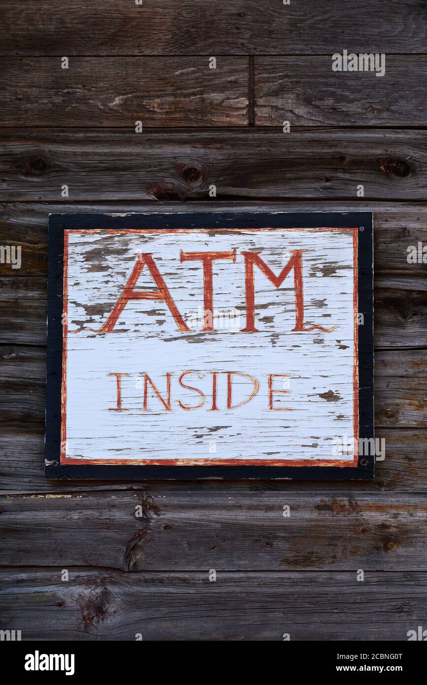 A handmade sign advises customers that an ATM machine is inside the ...
