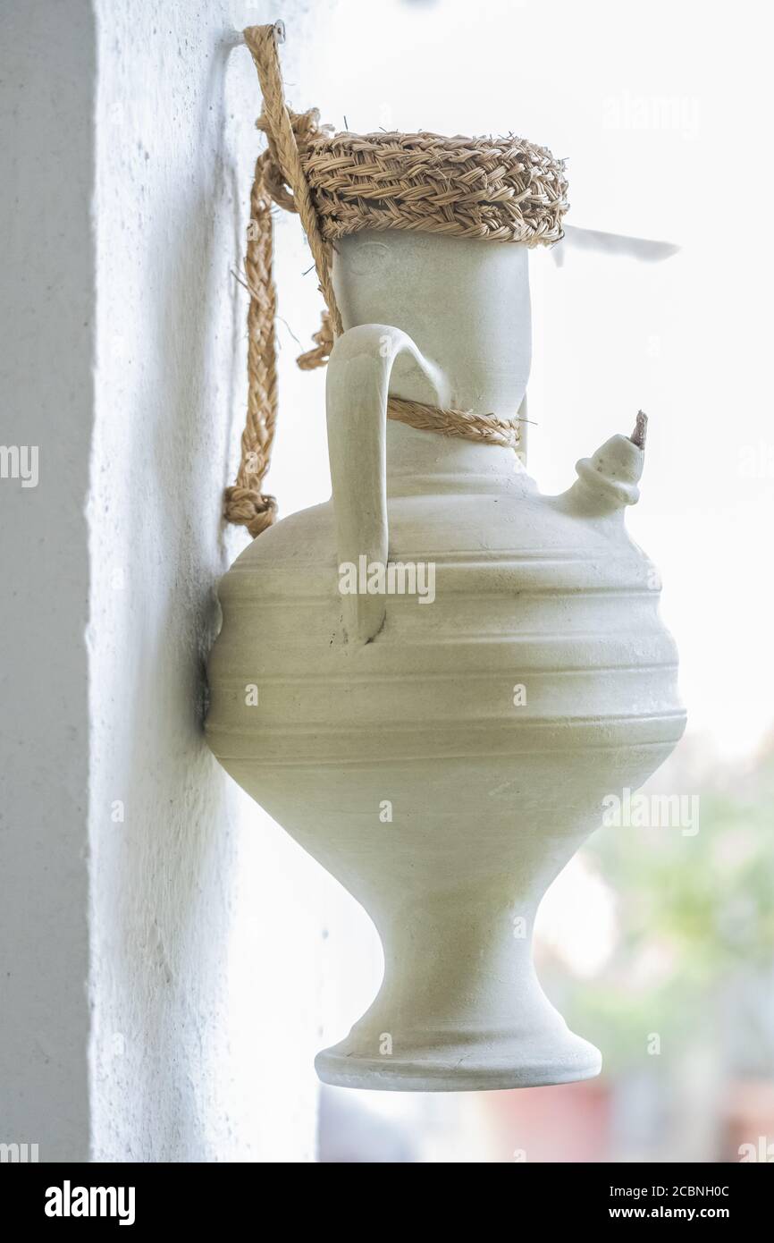 Beautiful white clay jug hanging from the wall with a rope Stock Photo ...