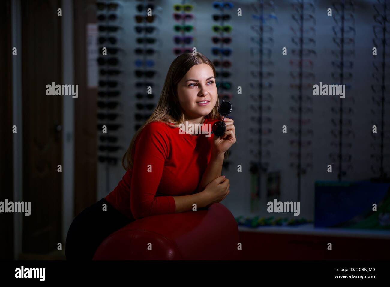 Beautiful young girl chooses sunglasses in an optics store Stock Photo ...