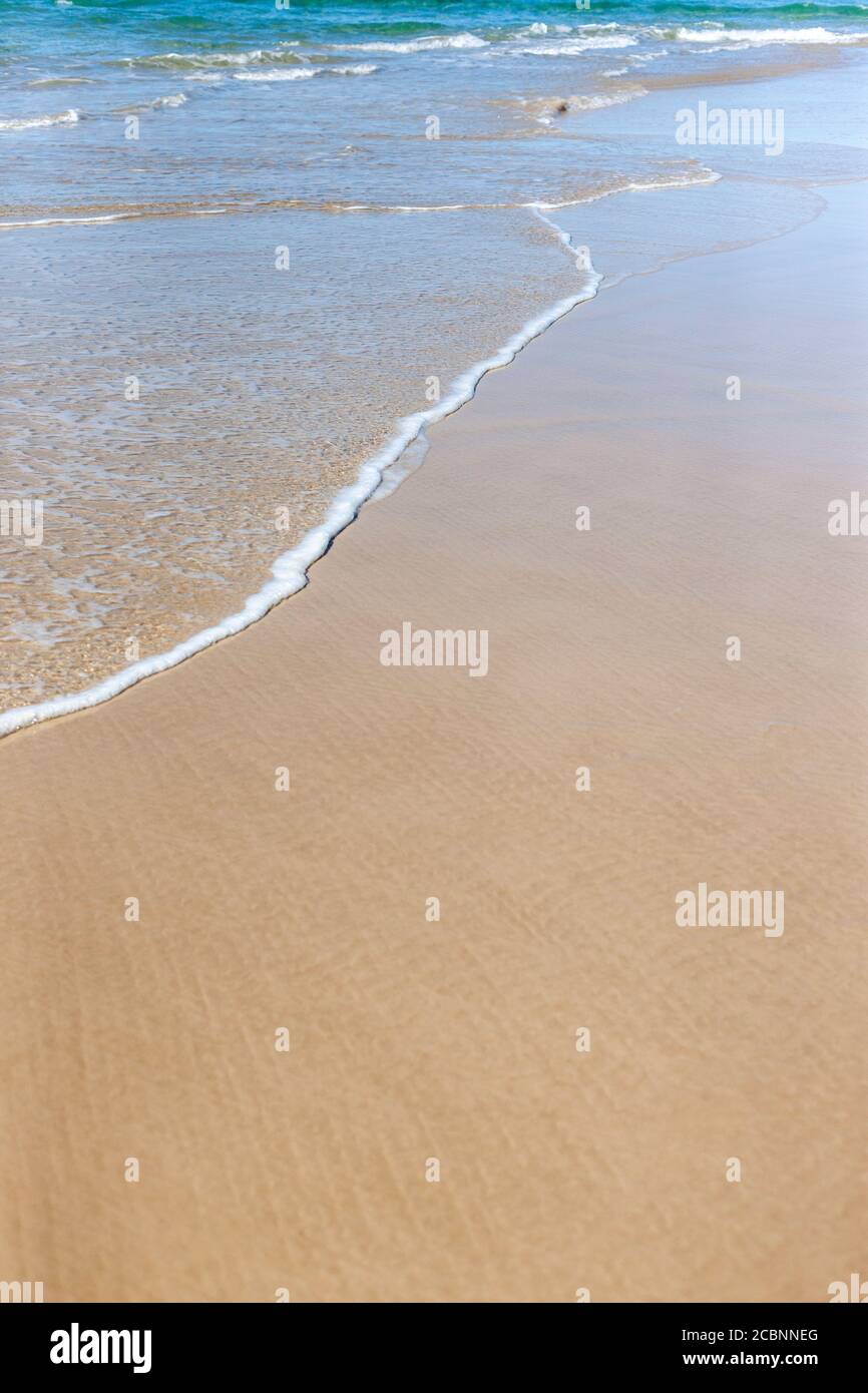 Calm ocean waves washing sand at the beach Stock Photo - Alamy