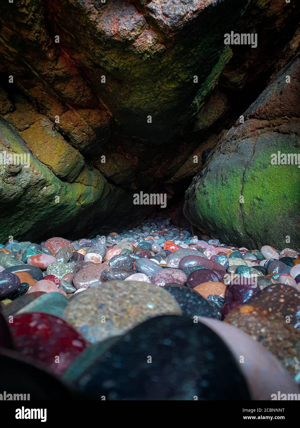 Rocky cave filled with colorful pebbles Stock Photo - Alamy