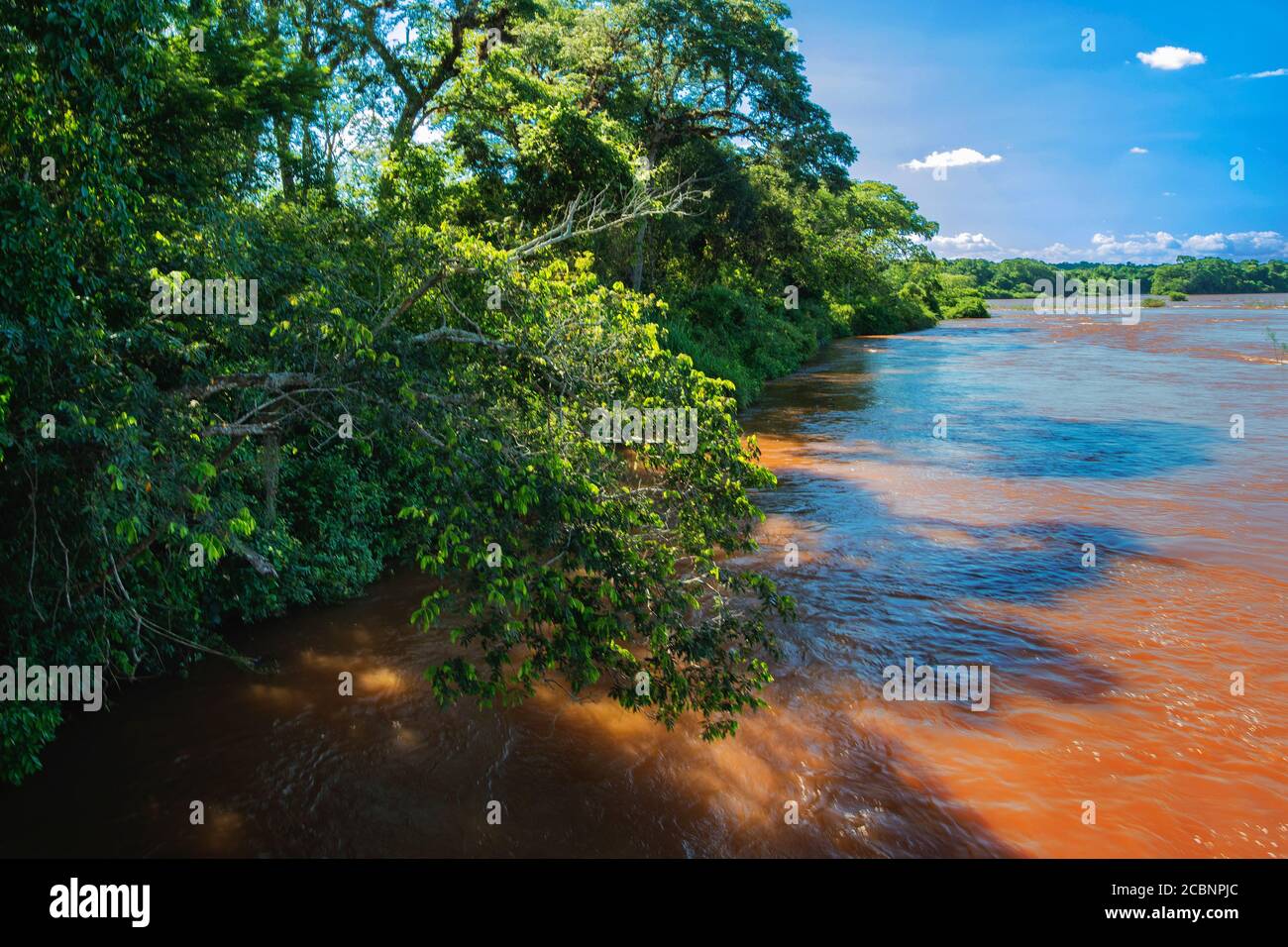 Red Iguazu river at Iguazu Falls National Park, tropical rapids and ...