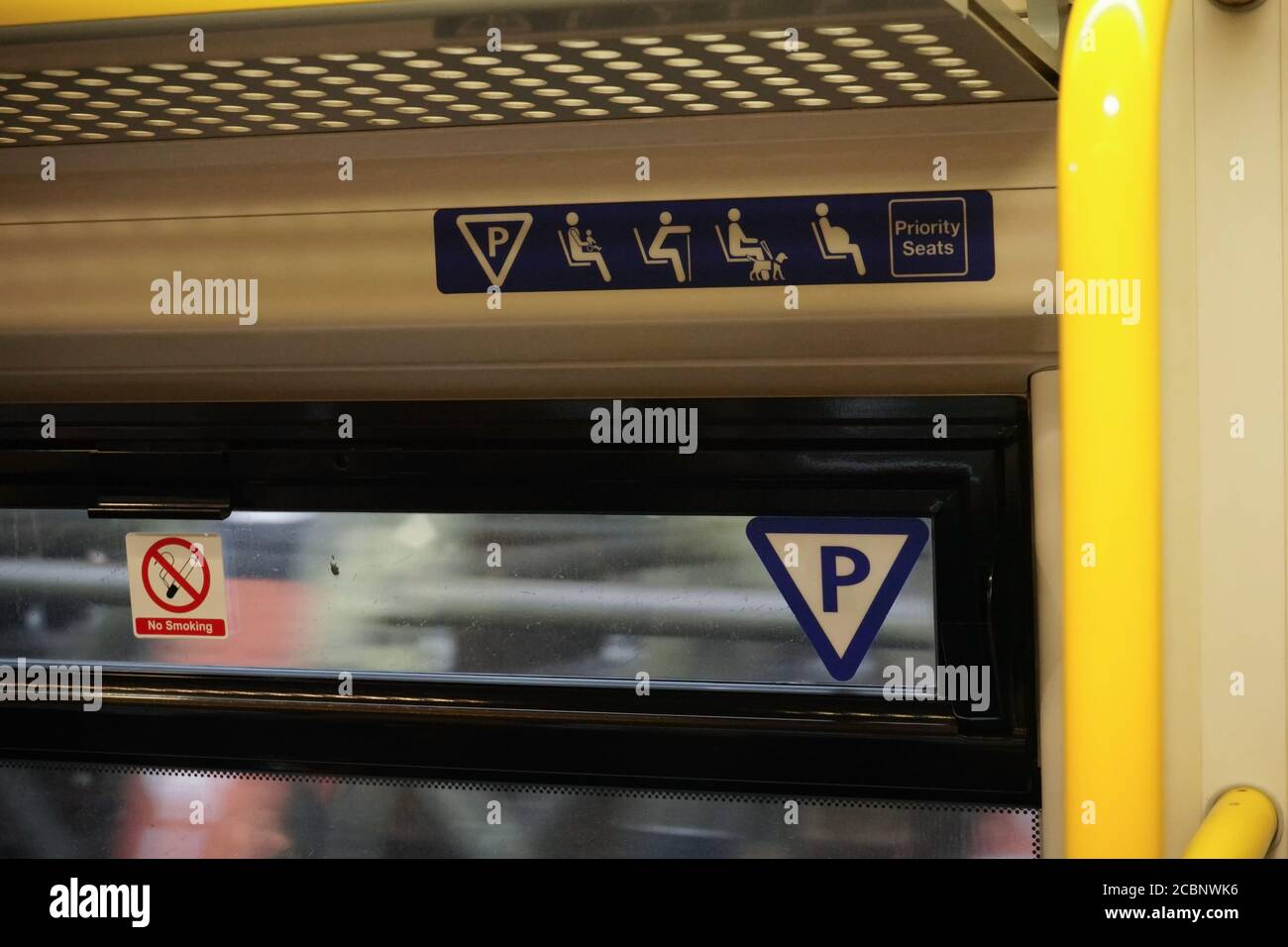 Priority seats and no smoking sign above window of London train Stock ...