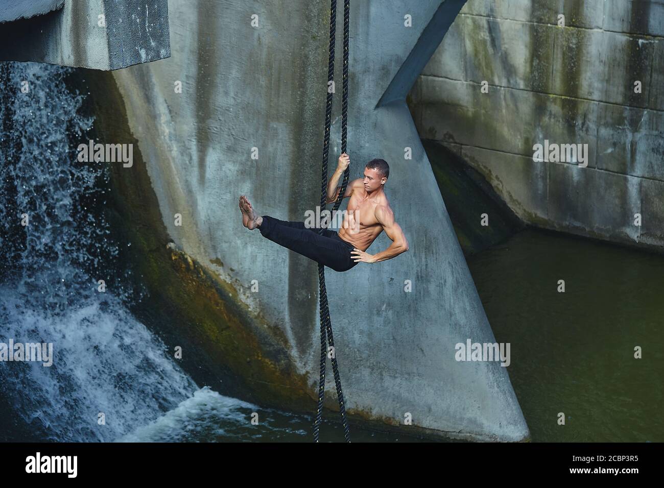 an athletic person performs dangerous exercises on a gymnastic rope. in ...
