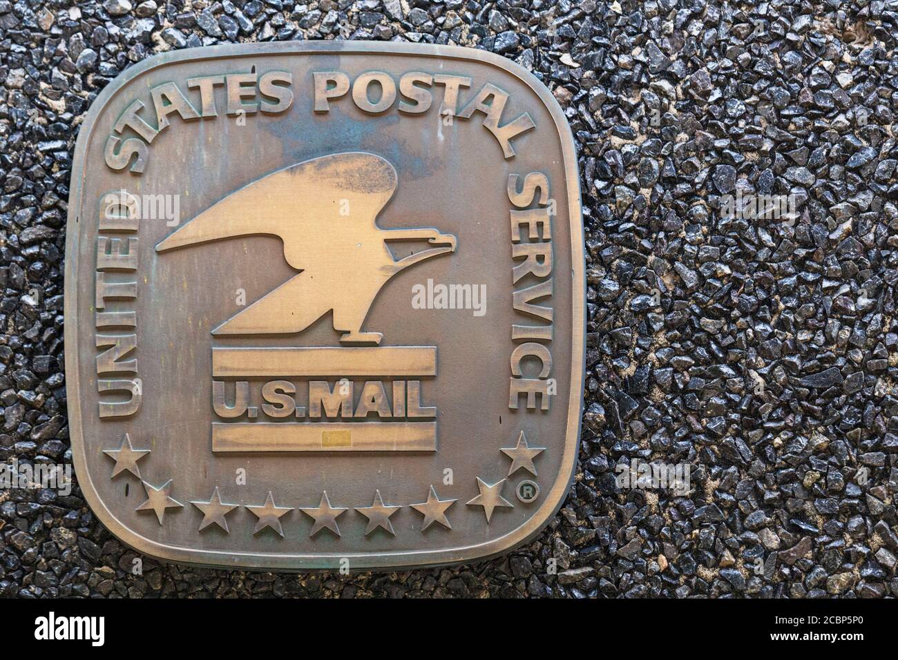 A plaque with the insignia of the Unites States Postal Service is on a ...